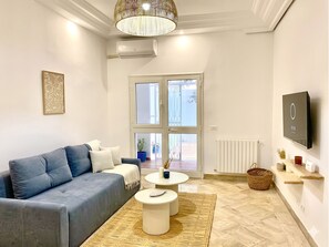 Apartamento conforto, banheiro privativo, vista para o jardim | Área de estar | TV de tela plana 55 cm com canais a cabo, serviços de streaming