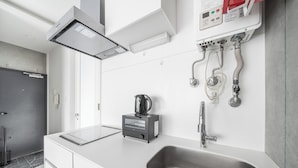 Uma cozinha moderna com uma pia de aço inoxidável, uma cafeteira embutida e um sistema de filtragem de água fixado na parede.