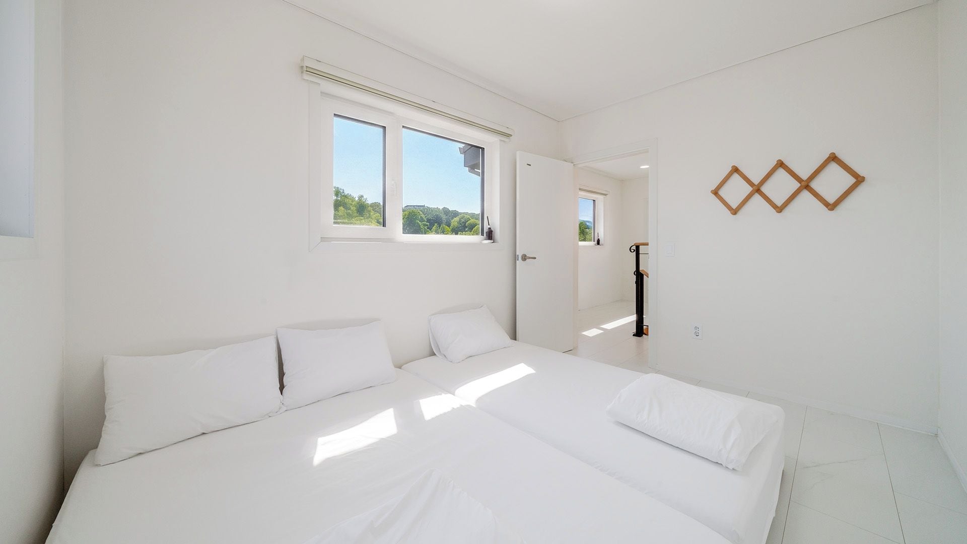 Quarto com uma cama grande, janela e porta.