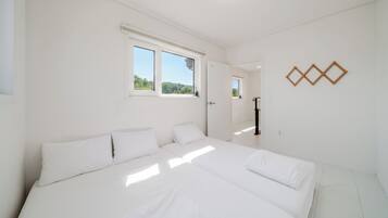 Quarto com uma cama grande, janela e porta.