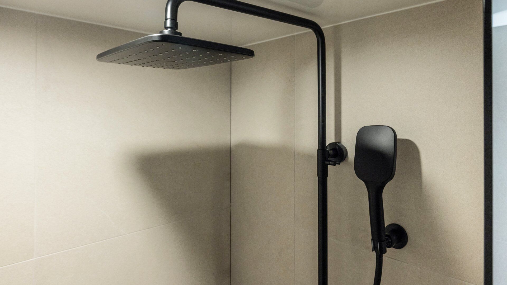 Chuveiro com design moderno, um chuveiro manual e um painel de controle.