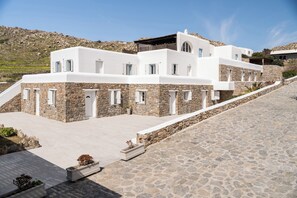 Um edifício moderno com fachada de pedra, várias janelas e telhado inclinado.