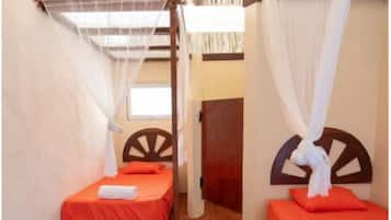 Quarto com duas camas, cabeceira de madeira, piso ladrilhado e teto com padrão trançado.