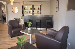 Uma sala de estar moderna com sofás de couro, uma mesa de centro e um espaço de bar com prateleiras cheias de garrafas.