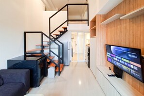 Um espaço de estar moderno com escada, televisão de tela plana e design minimalista.