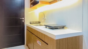 Uma cozinha moderna com micro-ondas embutido, pia e armário.