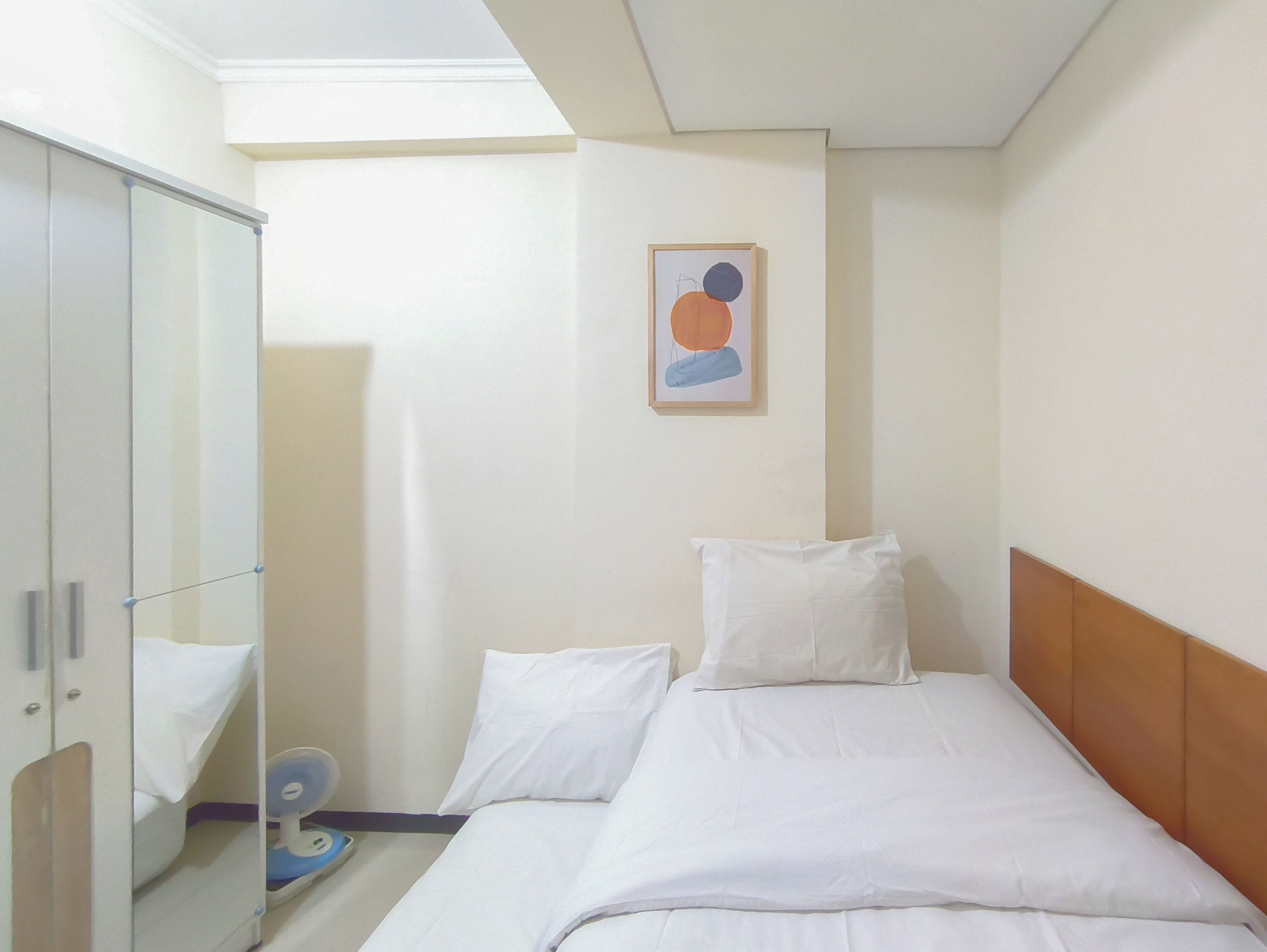 Quarto com cama, guarda-roupa, balança e uma obra de arte na parede.