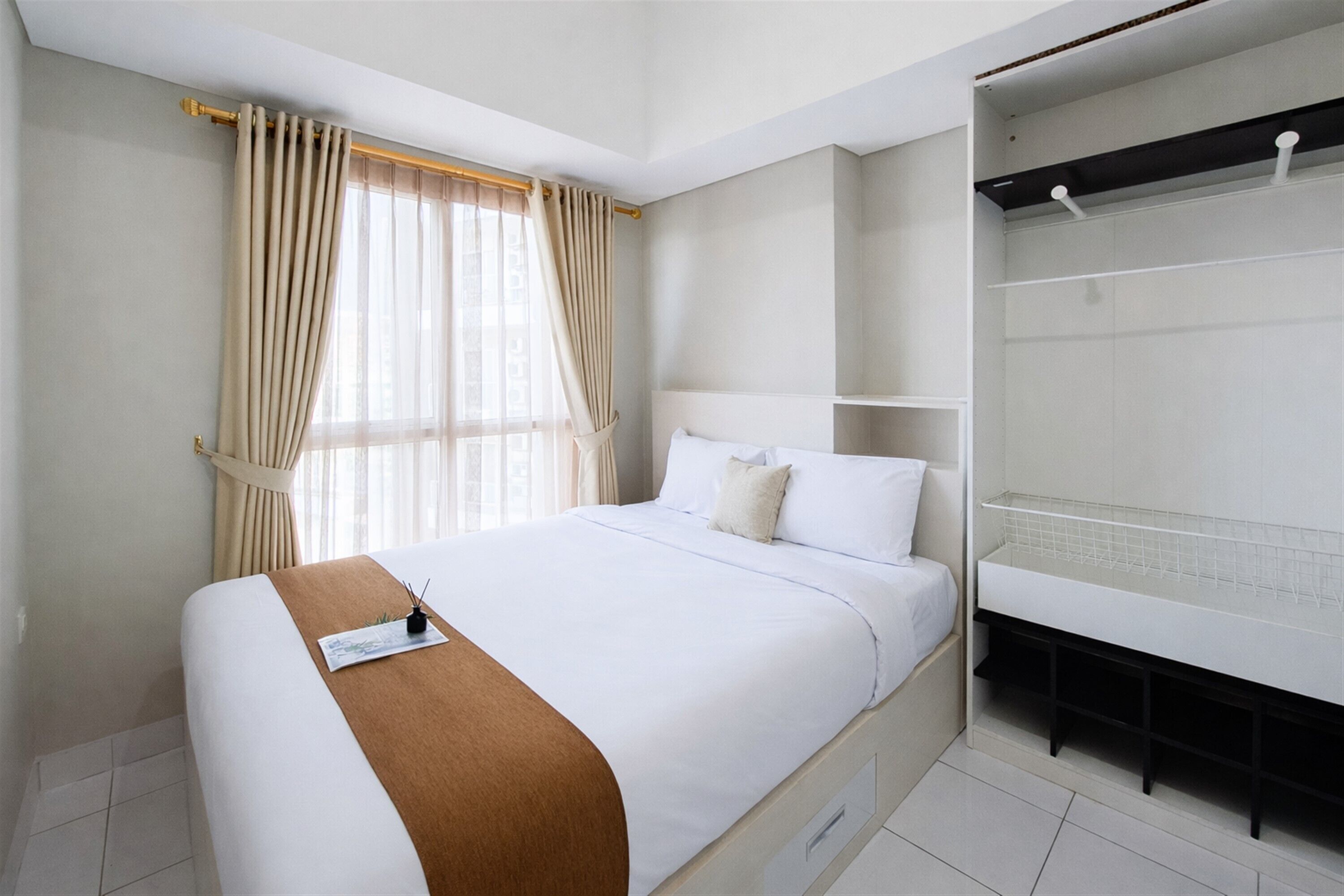 Quarto de hotel com cama grande, mesa de cabeceira, espelho, guarda-roupa e chuveiro.
