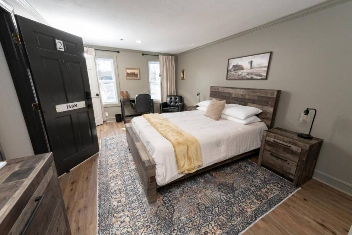 Quarto com cama, escrivaninha, cadeira, guarda-roupa e porta com a inscrição 'FARM'.