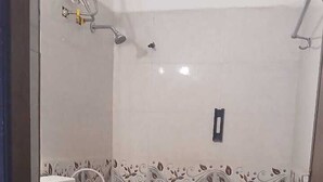 Um banheiro pequeno com vaso sanitário, pia e chuveiro.
