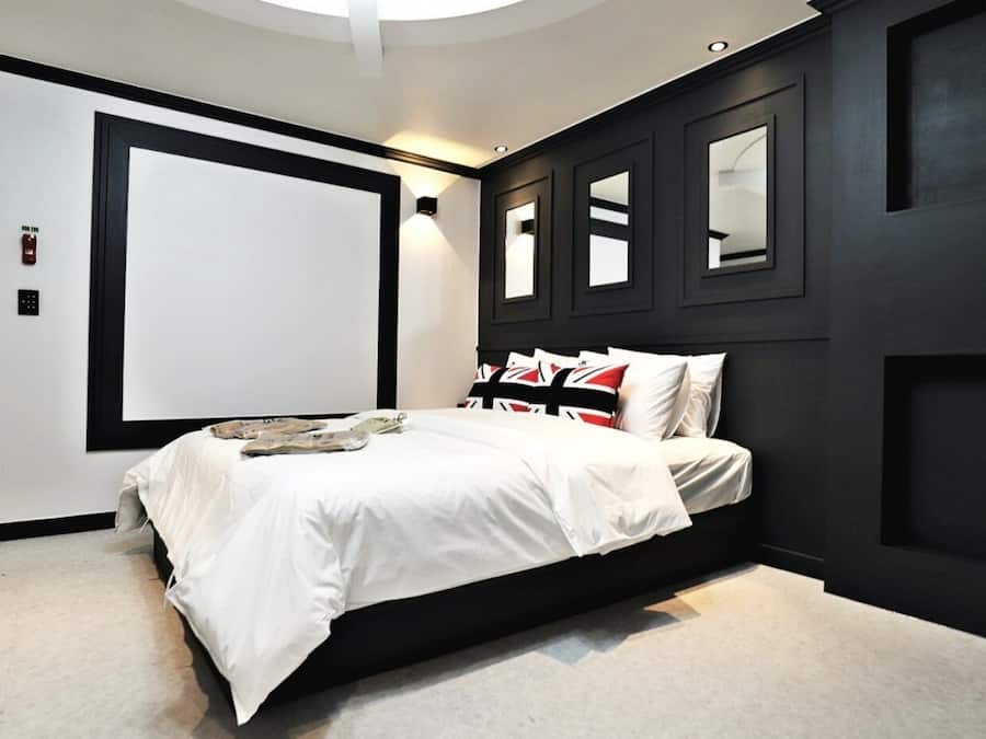 Quarto moderno com uma cama grande, um guarda-roupa e um espelho.