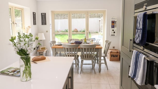 Cozinha com área de refeições e vista para o exterior, incluindo uma geladeira.