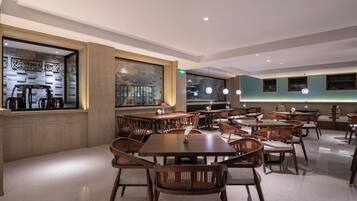 Um restaurante moderno com mobiliário de madeira, janelas amplas e um interior limpo.