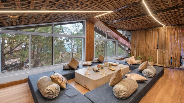 Um interior moderno com grandes janelas, teto tecido único e um espaço de estar acolhedor.