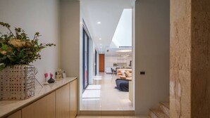 Um interior moderno com cozinha, sala de jantar e sala de estar, incluindo um sofá e uma mesa de centro.