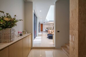 Um interior moderno com cozinha, sala de jantar e sala de estar, incluindo um sofá e uma mesa de centro.