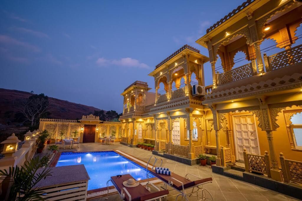 Um edifício tradicional com piscina, área de estar ao ar livre e detalhes arquitetônicos elaborados.