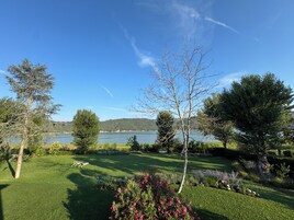 Um gramado bem cuidado com vista clara para um lago e colinas ao longe.