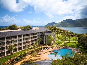 Um resort com piscina, várias varandas e vista para o oceano.