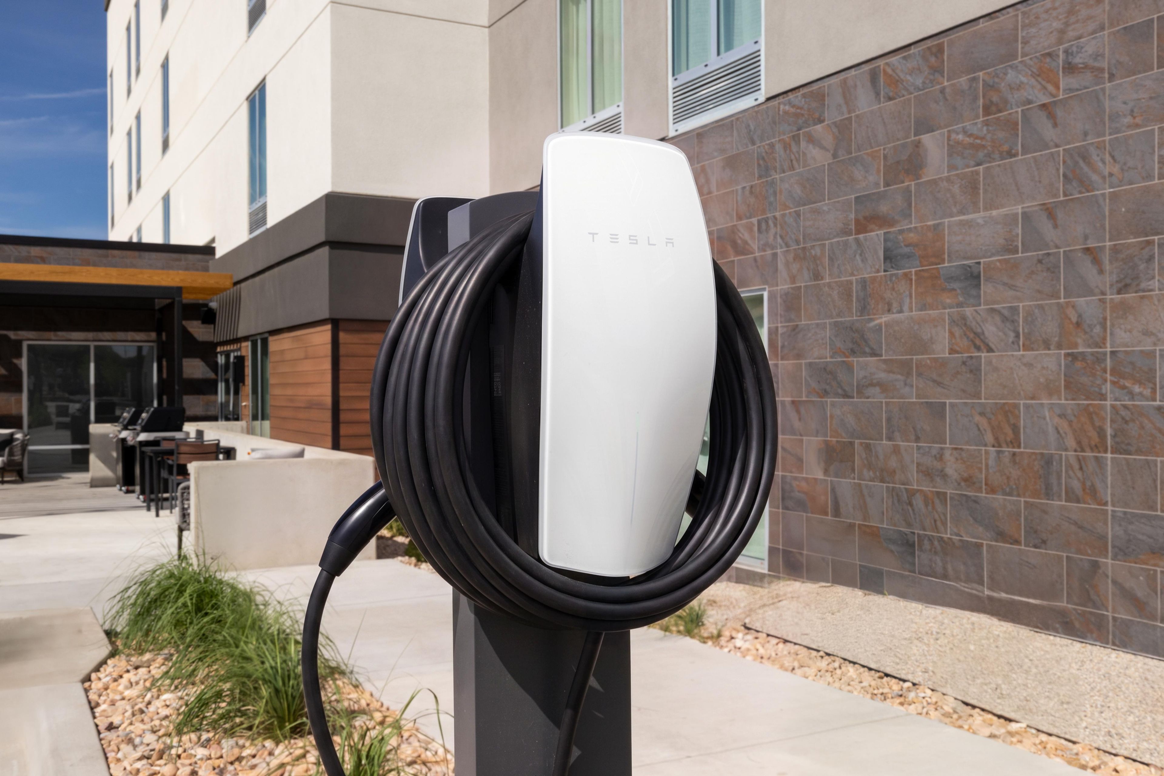 Estação de carregamento para veículo elétrico Tesla, com cabo enrolado.