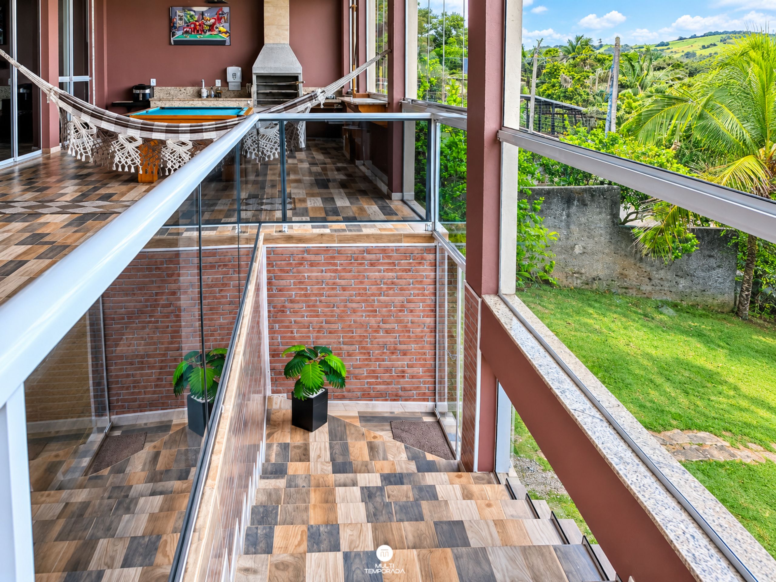 Espaço ao ar livre com vários níveis, piscina, área de churrasco e plantas em vasos.