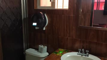 Casa de banho com sanita, lavatório e espelho.