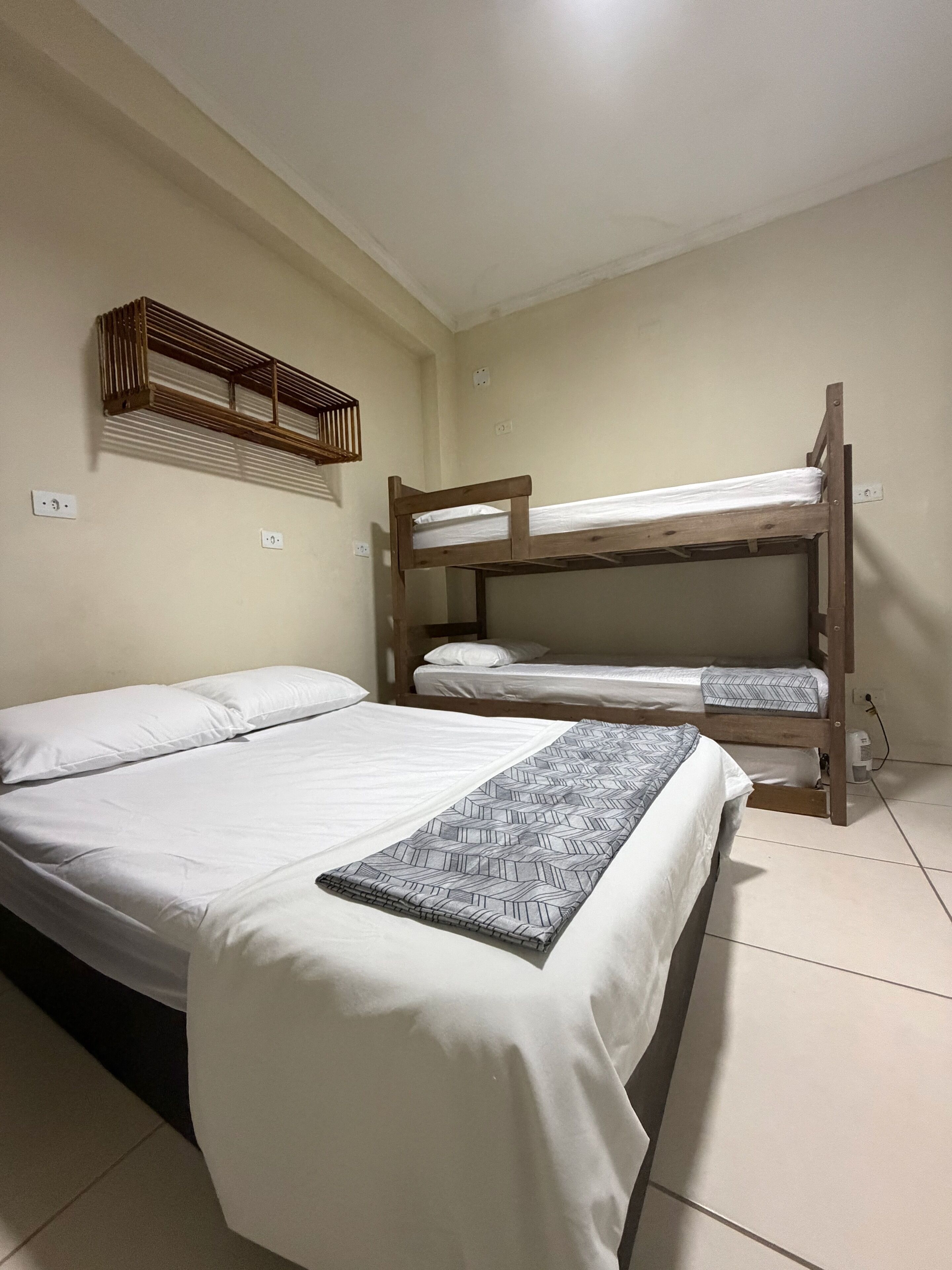 Quarto com uma cama de solteiro e uma beliche.