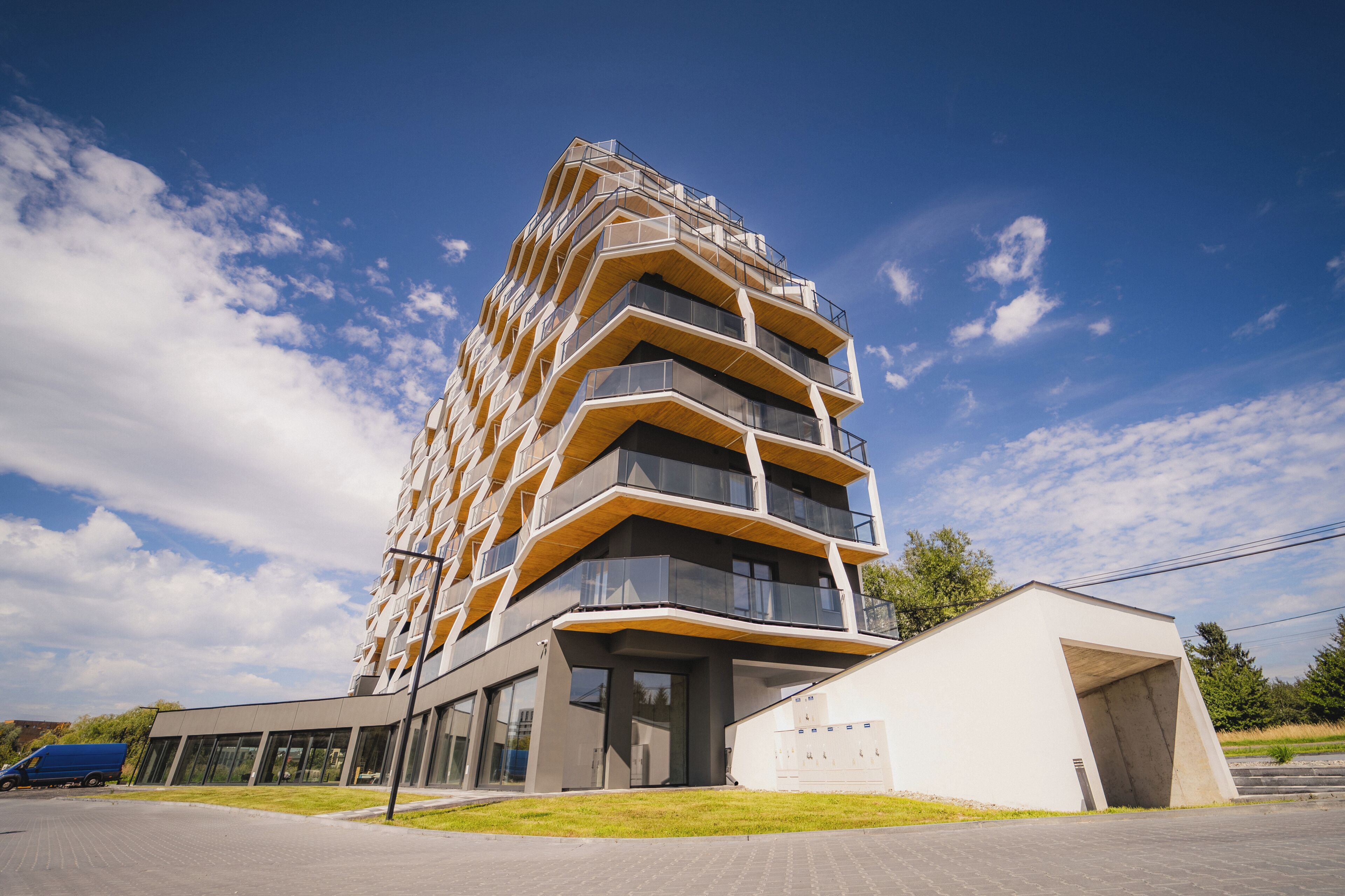 Um edifício de vários andares com um design arquitetônico único, com varandas e janelas grandes.