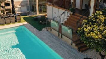 Um imóvel residencial com piscina, banheira de hidromassagem e varanda com vista para a paisagem ao redor.