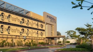 Um edifício com uma placa que diz 'PRIDE ELITE' e um design arquitetônico moderno com padrões geométricos.