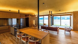 Cozinha moderna com ilha central, soalho em madeira e vista para o exterior.