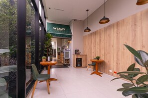 Interior moderno com parede de madeira, toldo verde e vista para um jardim.