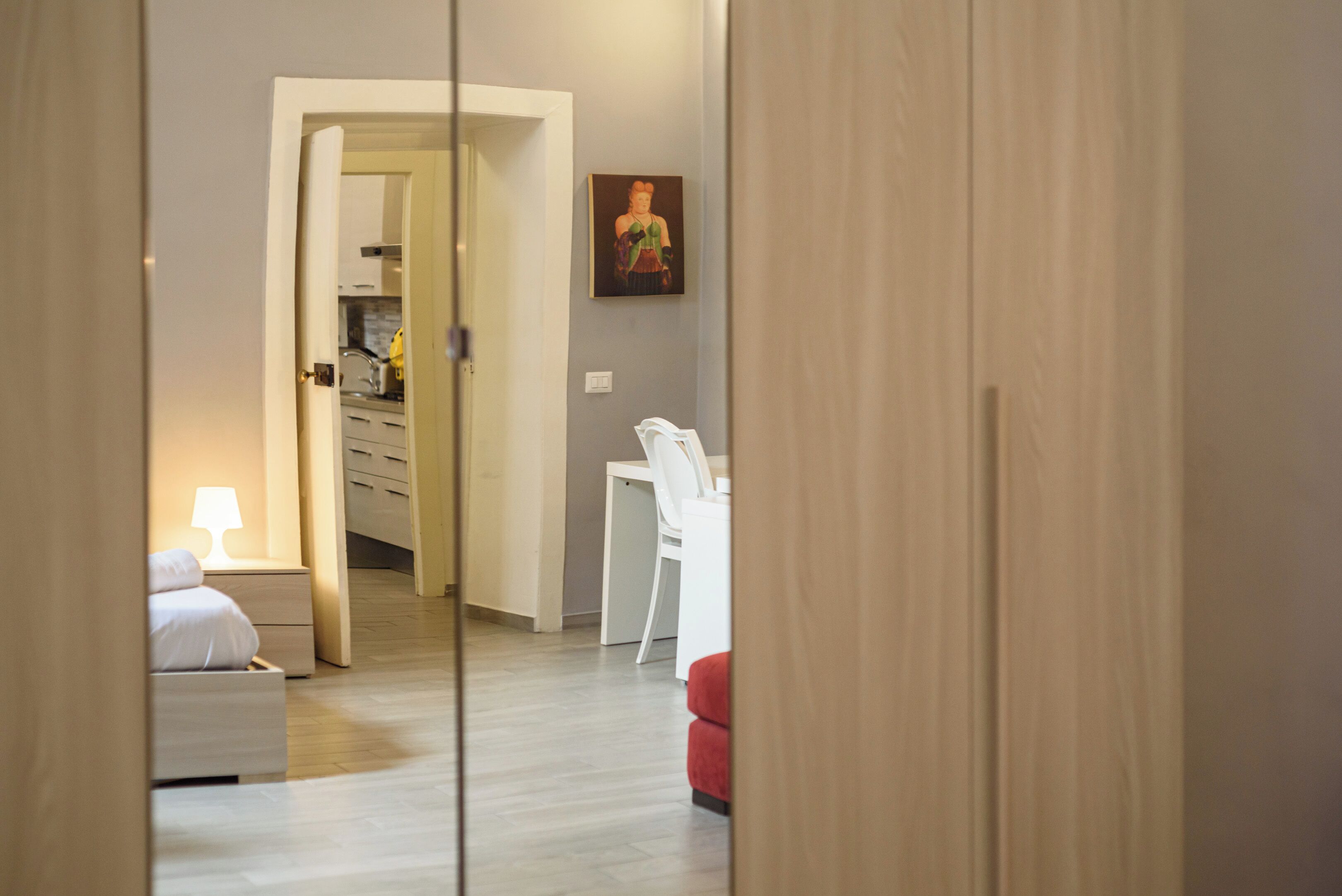 Quarto de hotel com uma cama, uma escrivaninha e uma cadeira.