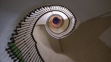 Uma escada em espiral com um pilar central e balaústres pretos.