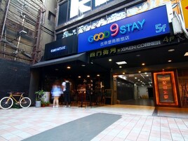 Entrada de hotel com placa indicando 'Good 9 Stay' e 'XIMEN CORNER 4F'.