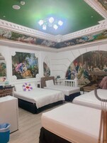 Quarto com duas camas, um mural no teto e um candelabro.