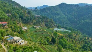 Paisagem acidentada com campos em socalcos e edifícios dispersos.