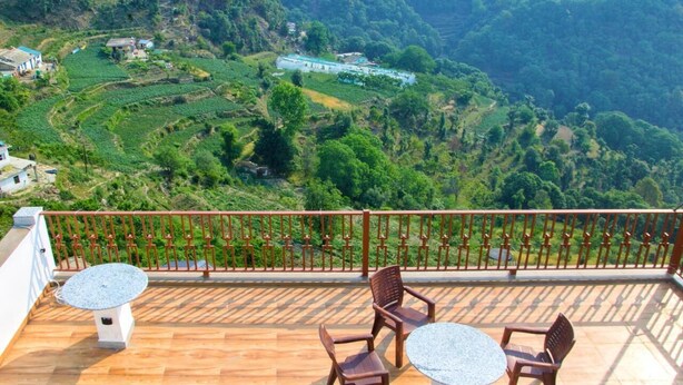 Um terraço com vista para campos em socalcos e um edifício ao longe.
