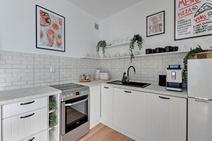 Apartamento | Cozinha privada | Uma chaleira elétrica, uma cadeira de bebé, mesas de jantar 