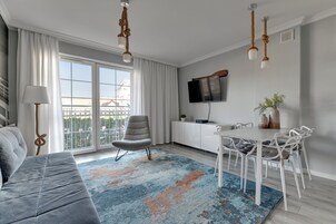 Apartamento família, vista para a cidade | Área de estar | TV 45 polegadas com canais a cabo