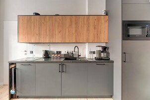 Apartamento Deluxe, kitchenette, vista para o pátio | Cozinha privada | Uma torradeira, uma cadeira de bebé, Congelador, Rolo de cozinha 