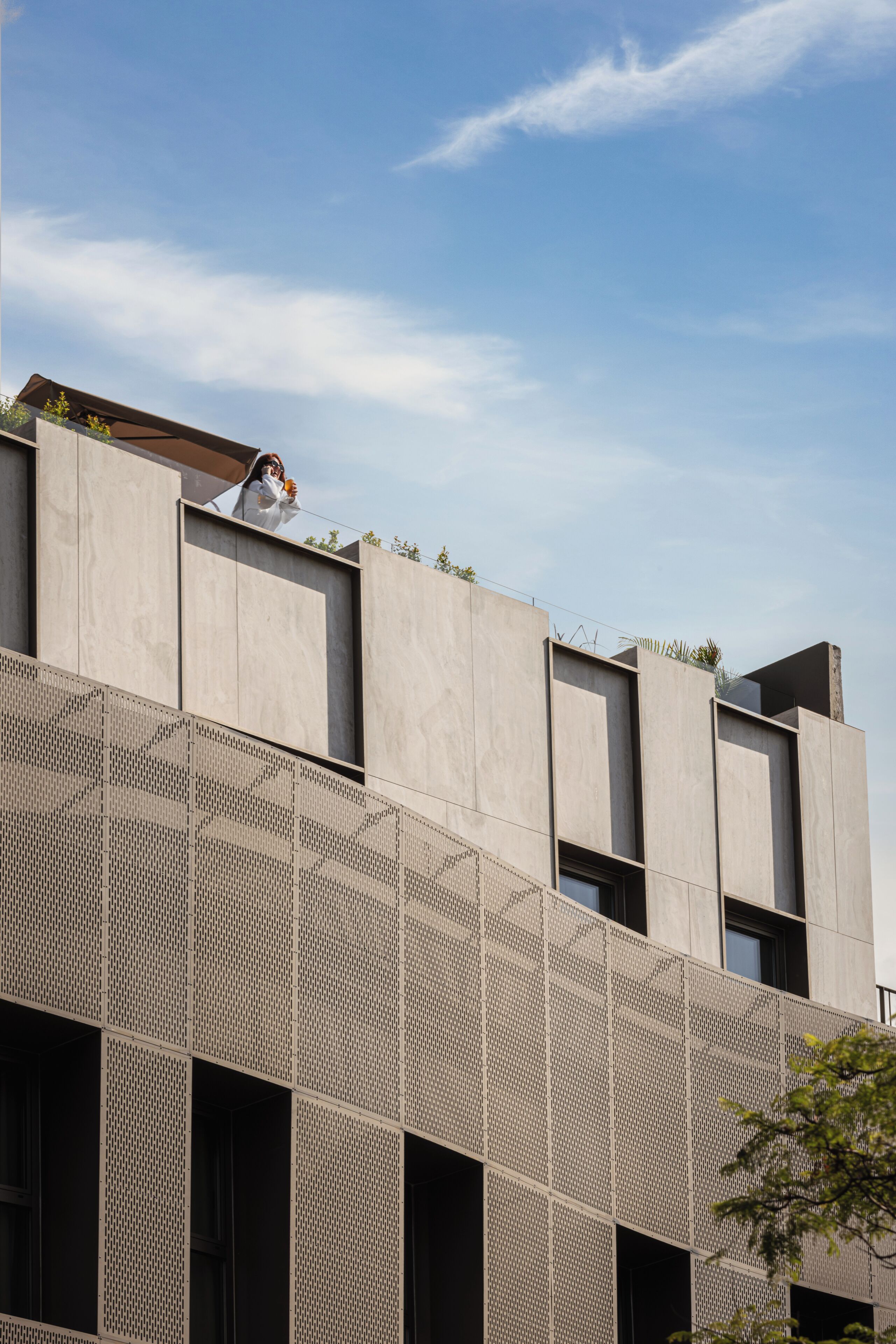 Um edifício moderno com telhado plano, grandes janelas e fachada em tela.