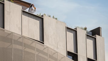 Um edifício moderno com telhado plano, grandes janelas e fachada em tela.