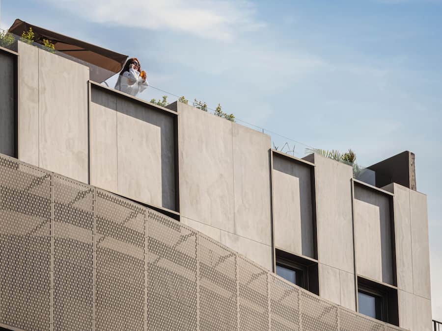 Um edifício moderno com telhado plano, grandes janelas e fachada em tela.