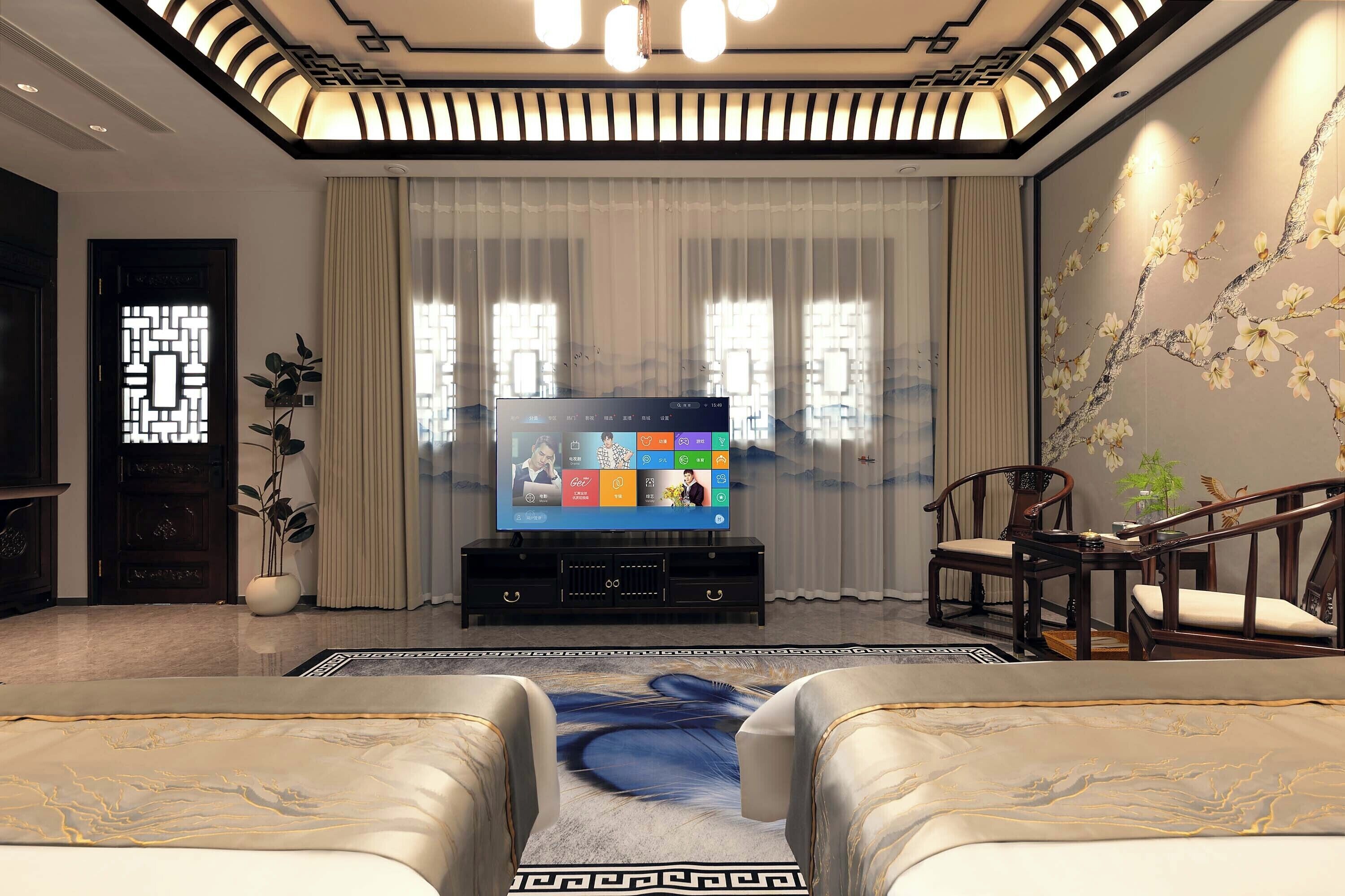 Uma sala de estar com televisão, sofá, mesa de centro e decoração na parede.