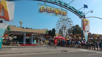 Uma roda gigante e uma placa com a palavra 'Gibione' escrita.