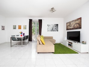 Uma sala de estar moderna com sofá, TV e obras de arte.