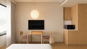 Quarto de hotel com cama, televisão, mesa pequena com duas cadeiras, micro-ondas e janela com cortinas.