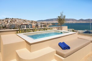 Piscina no terraço com vista para a cidade e montanhas.