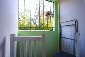 Quarto com janela, radiador e uma cadeira.